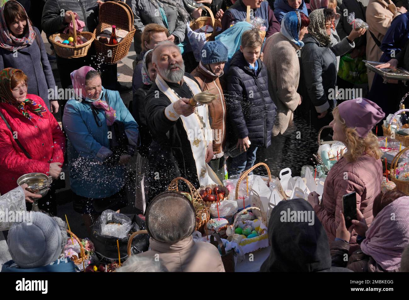 An Orthodox priest blesses believers and traditional Easter cakes and ...