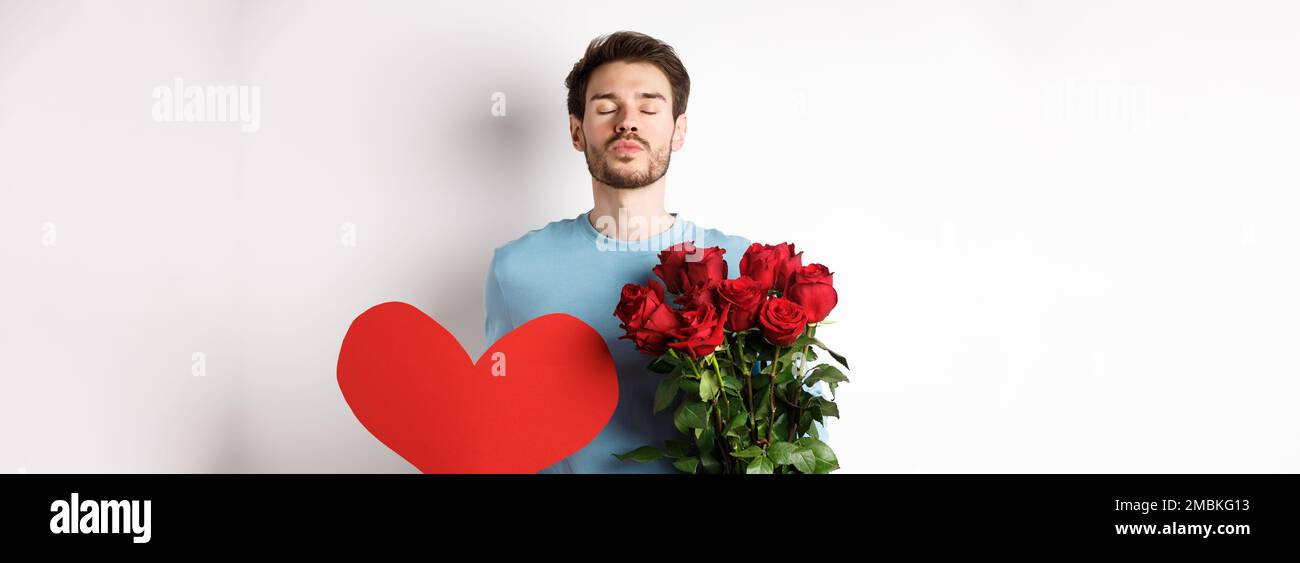 Romantic boyfriend waiting for kiss, holding bouquet of roses flowers ...