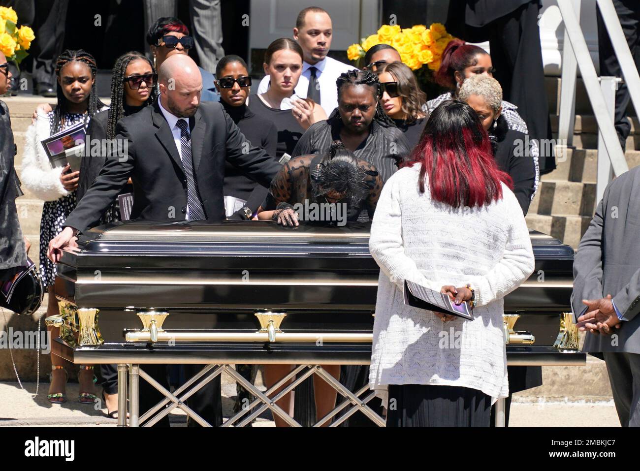 Friends and family console Kalabrya Haskins, center, as she leans over ...