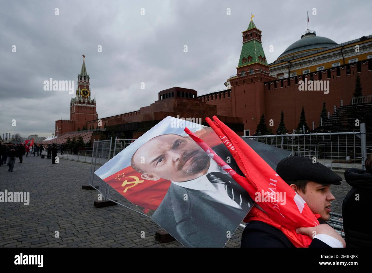 Russian communists carry a portrait of Lenin and their red flags after ...