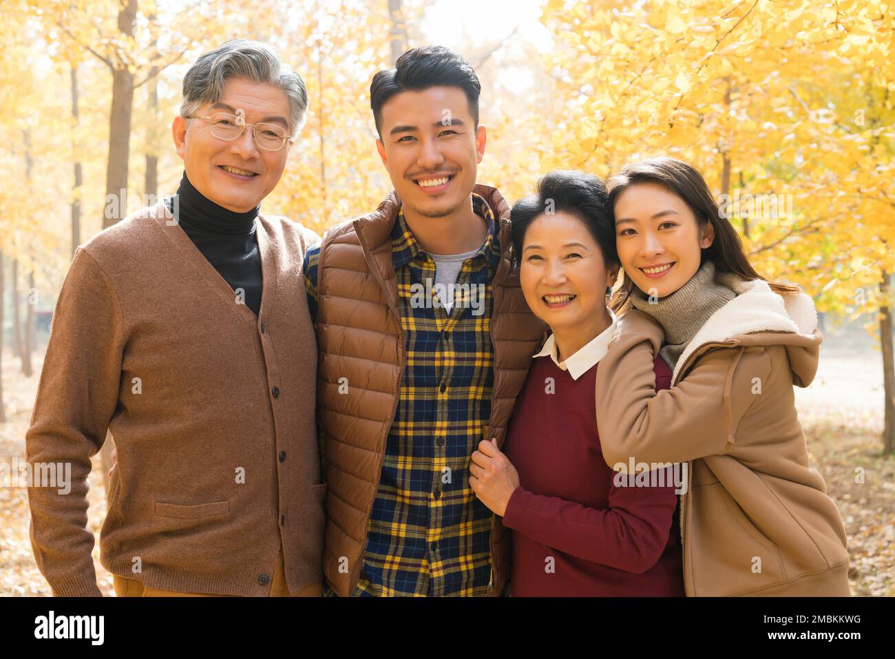 The happy family of four autumn stroll ginkgo Lin Stock Photo - Alamy