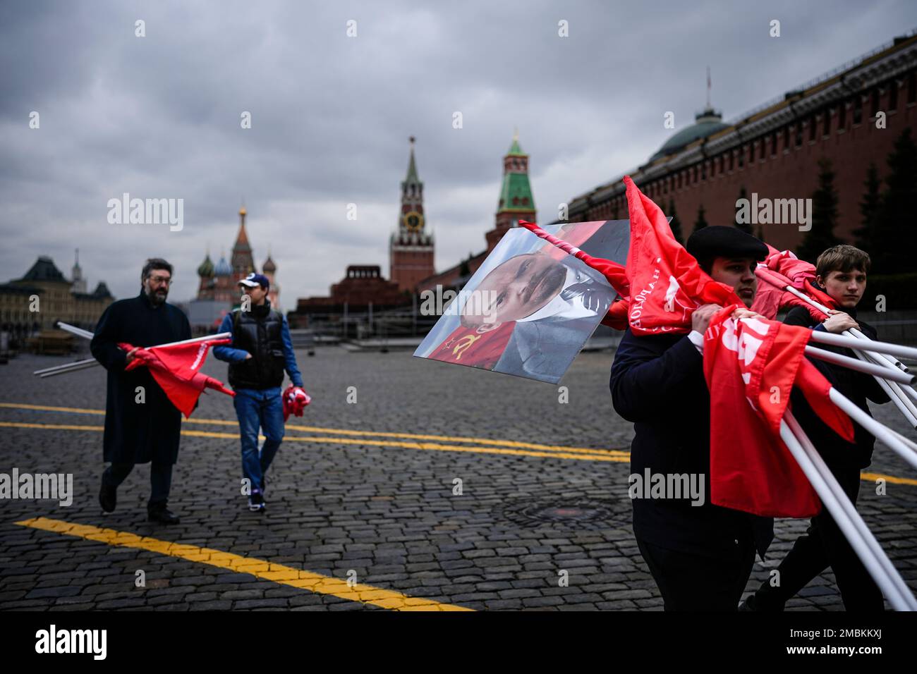 Russian communists carry a portrait of Lenin and their red flags after ...