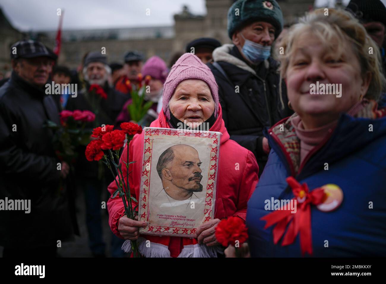 An elderly woman holds a portrait of Lenin as Russian communists and ...