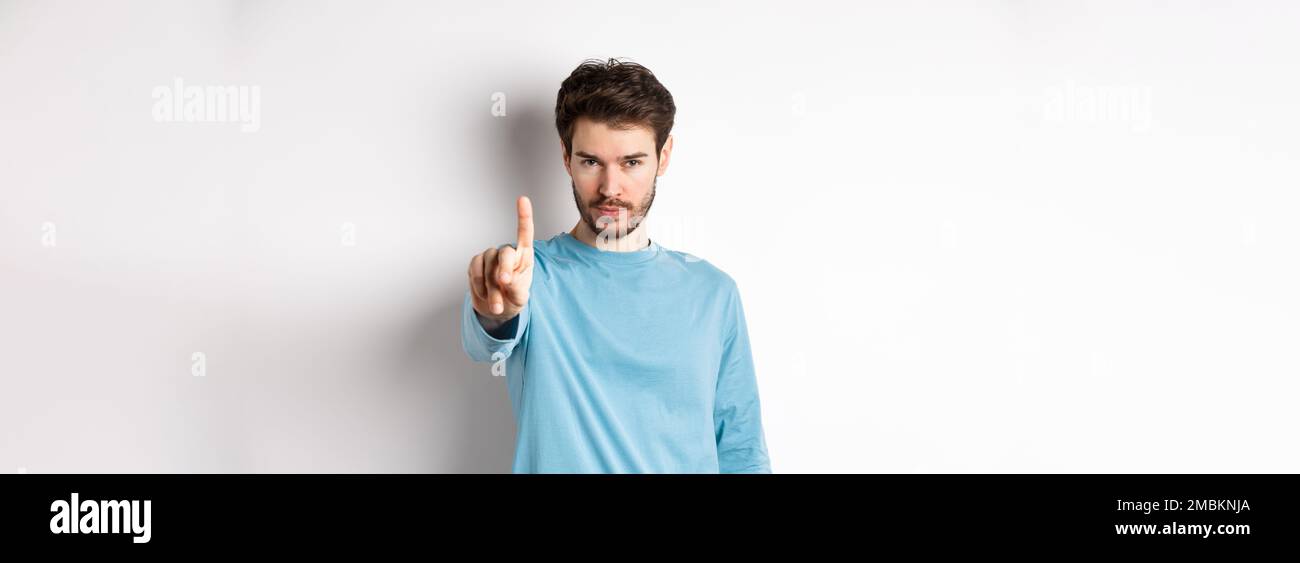 Image of serious young man with beard, shaking finger in disapproval ...