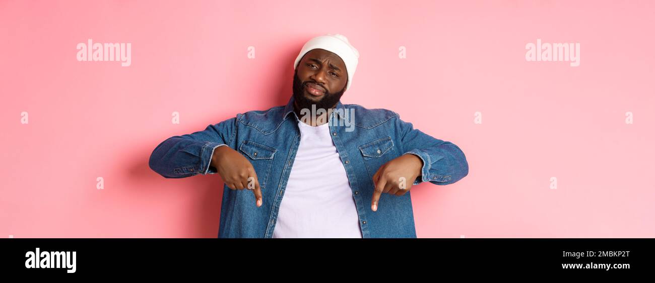 Skeptical and doubtful Black guy staring at camera unamused, pointing ...