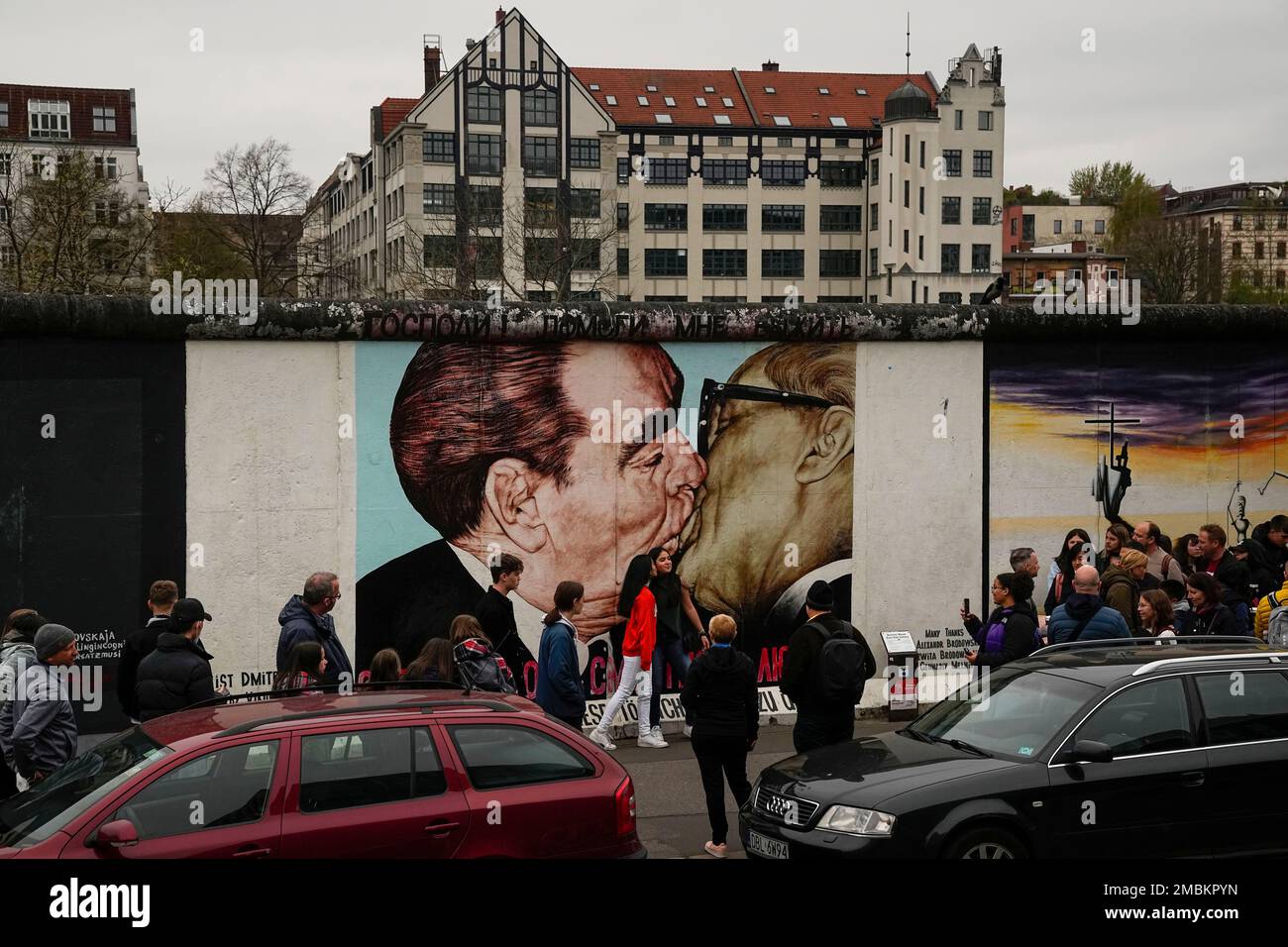 Women pose in front of the artwork by Russian artist Dmitry Vrubel ...