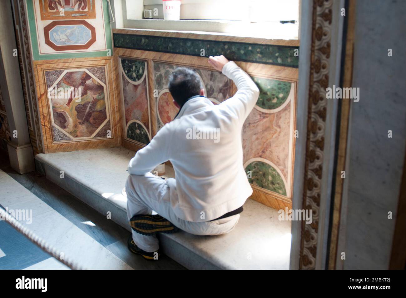 A conservator works to restore artwork in the halls of the Vatican ...
