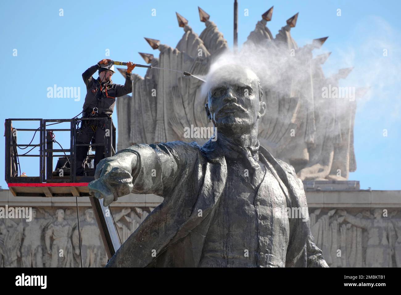 A worker of the Museum of Urban Sculpture washes a statue of Soviet ...