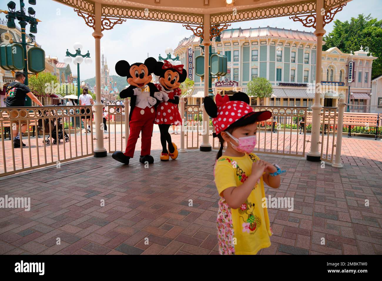 A girl wearing a face mask poses for a photograph with the iconic ...