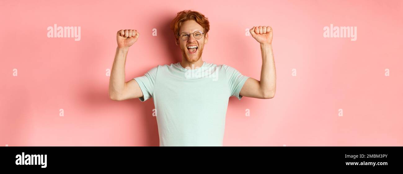 Happy winner with red hair and beard celebrating victory, shouting yes ...