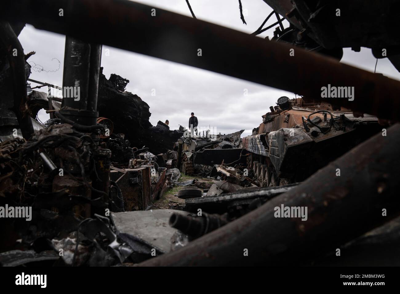 A local man stands atop of destroyed Russian armoured vehicles in Bucha ...