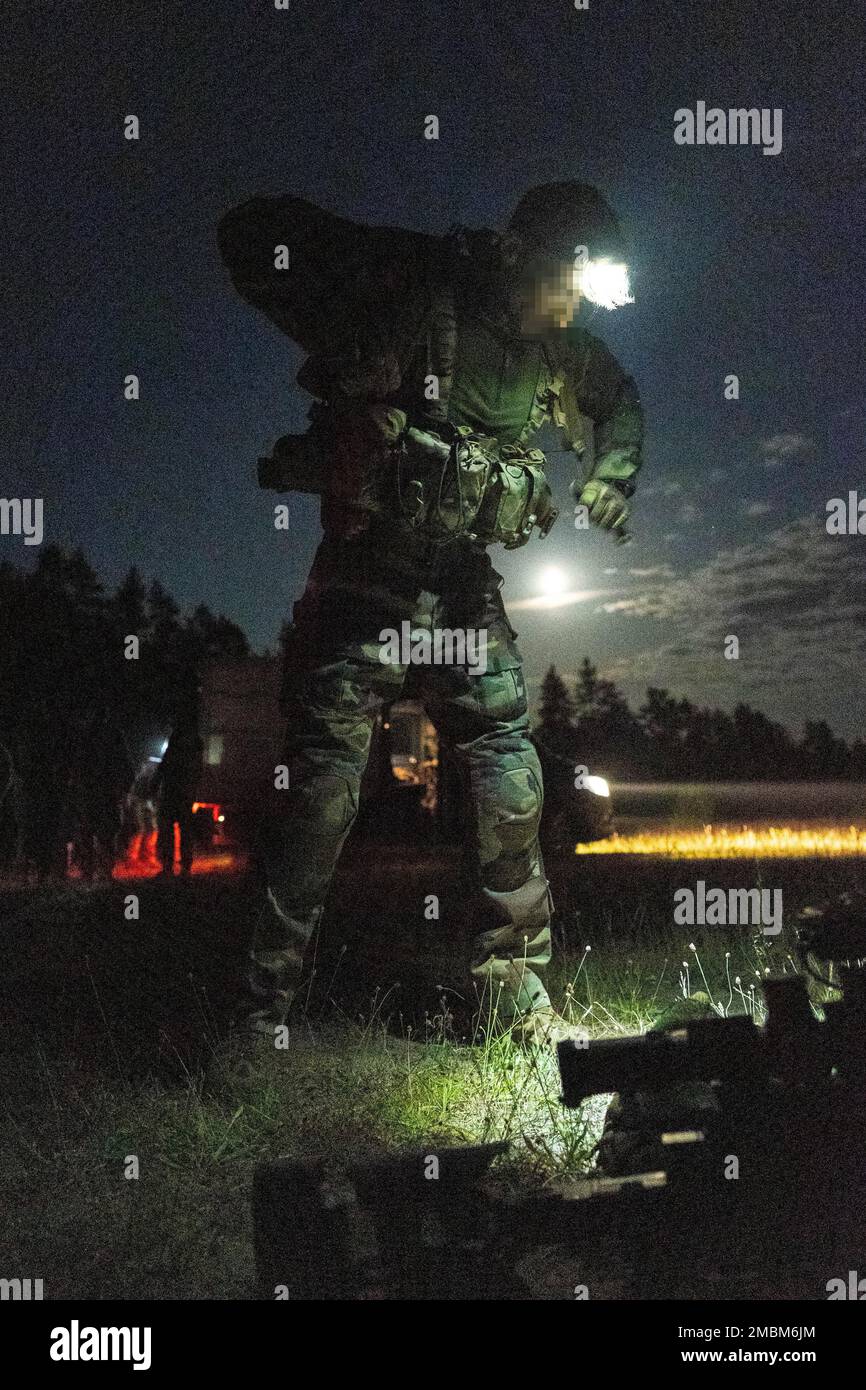 A Greek Special Forces Sniper prepares his gear during a night-time ...