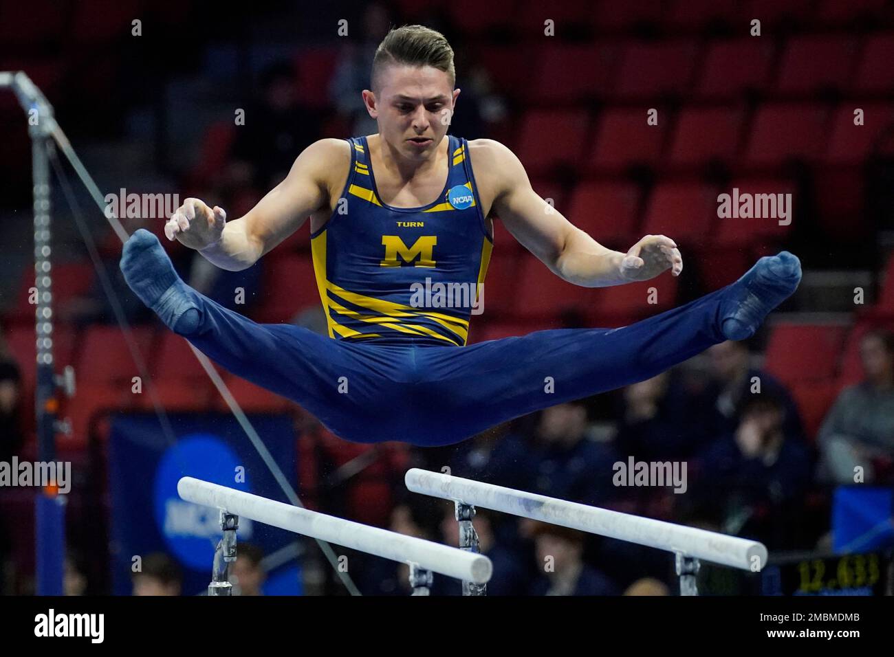 Michigan's Paul Juda competes on the parallel bars during the NCAA ...