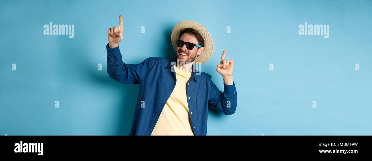 Funny tourist dancing on vacation, pointing fingers up, wearing summer ...