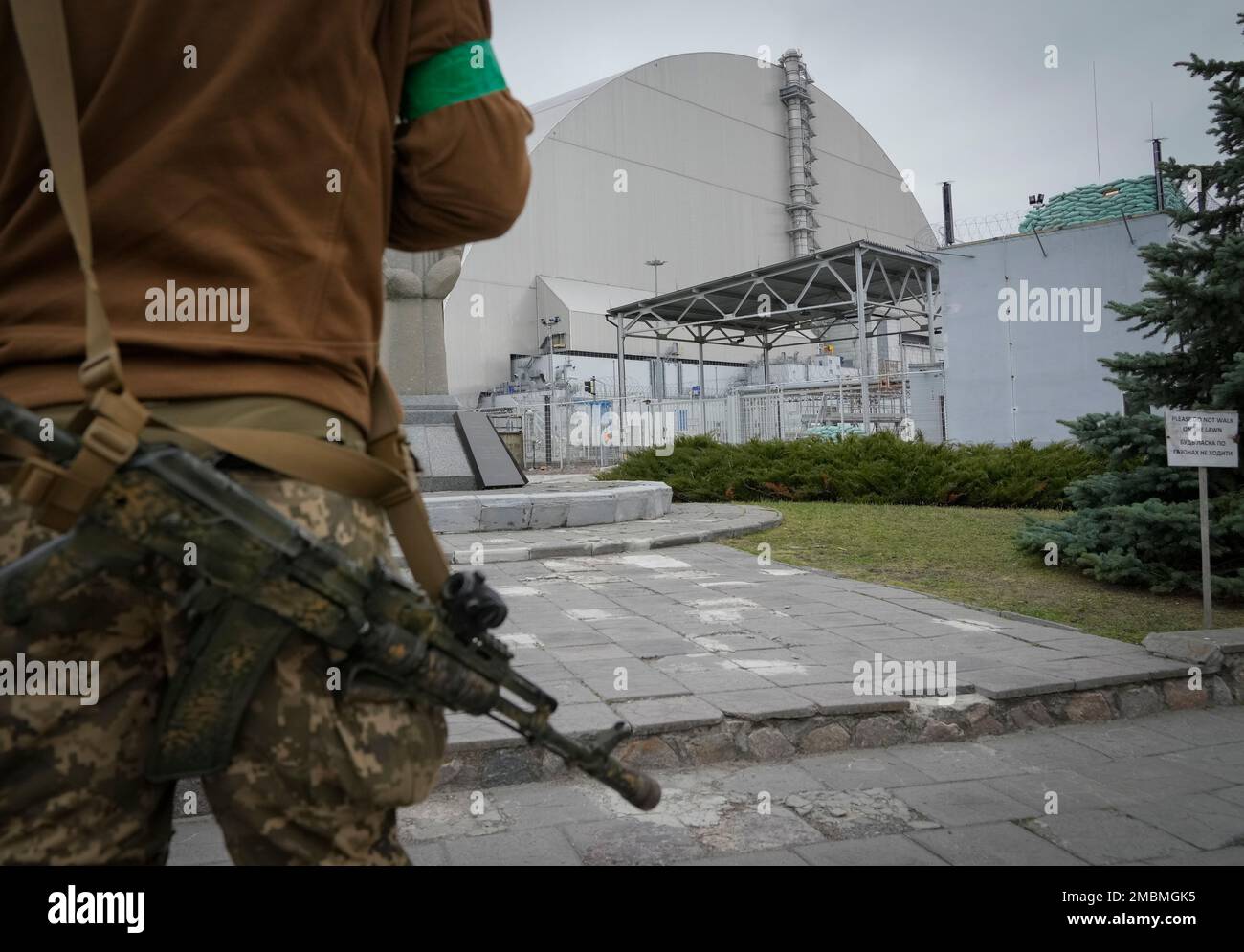 A Ukrainian soldier stands against the background of a shelter above ...