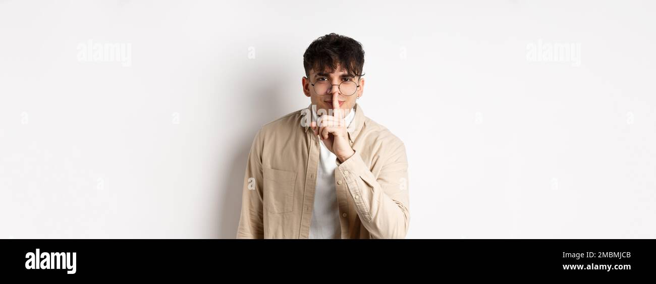 Cheerful handsome man in glasses share a secret, making surprise, lean ...