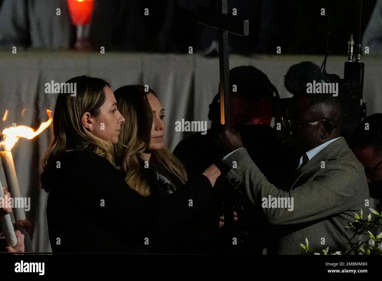 Two nurses from Russia and Ukraine, left, are handed over the cross as ...