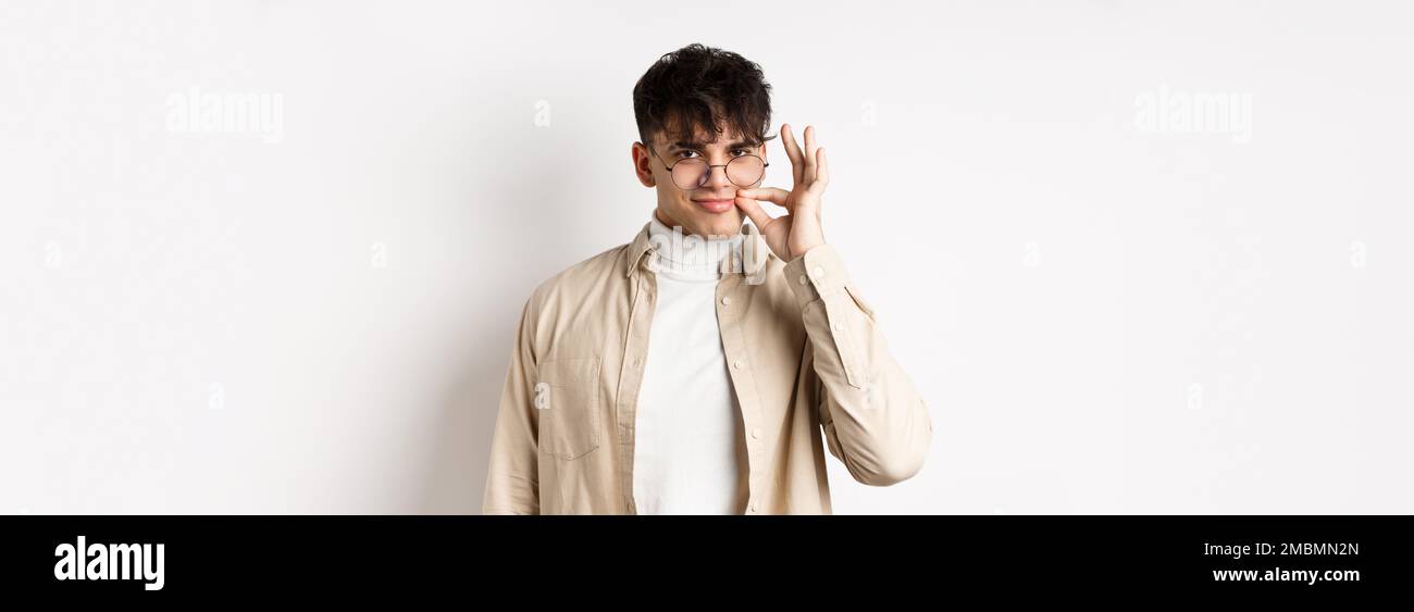 Smiling cunning guy in glasses shut his mouth on zipper, showing seal ...