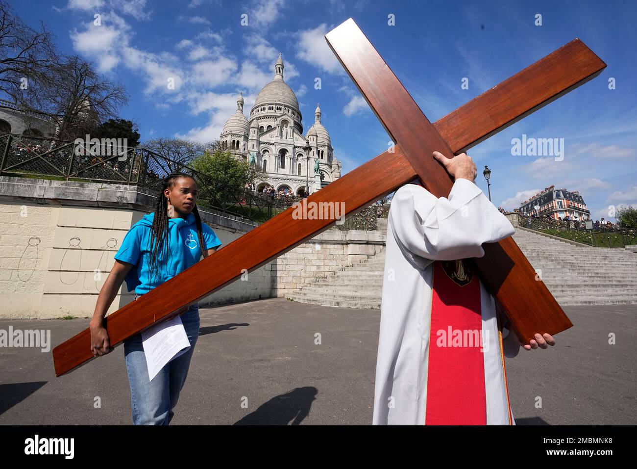 A cleric carries a wooden cross during the Way of the Cross ceremony as ...