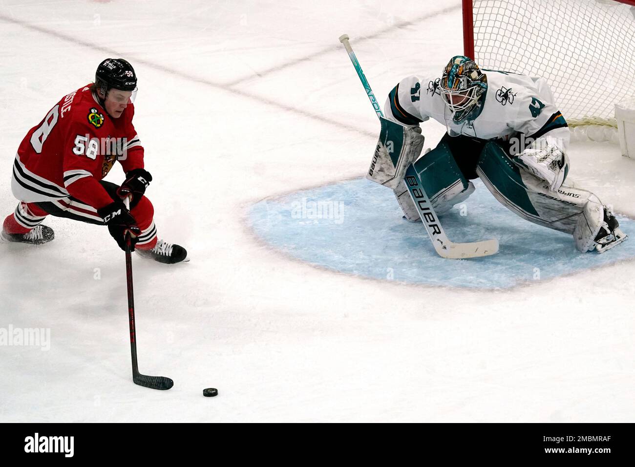 Chicago Blackhawks right wing MacKenzie Entwistle, left, tries to shoot ...