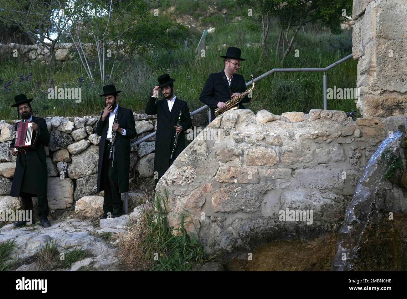 Ultra-Orthodox Jews play music moments before they collect water from a ...