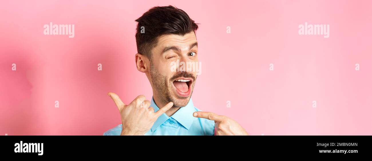 Cheeky and funny guy showing phone gesture, asking to call him and ...