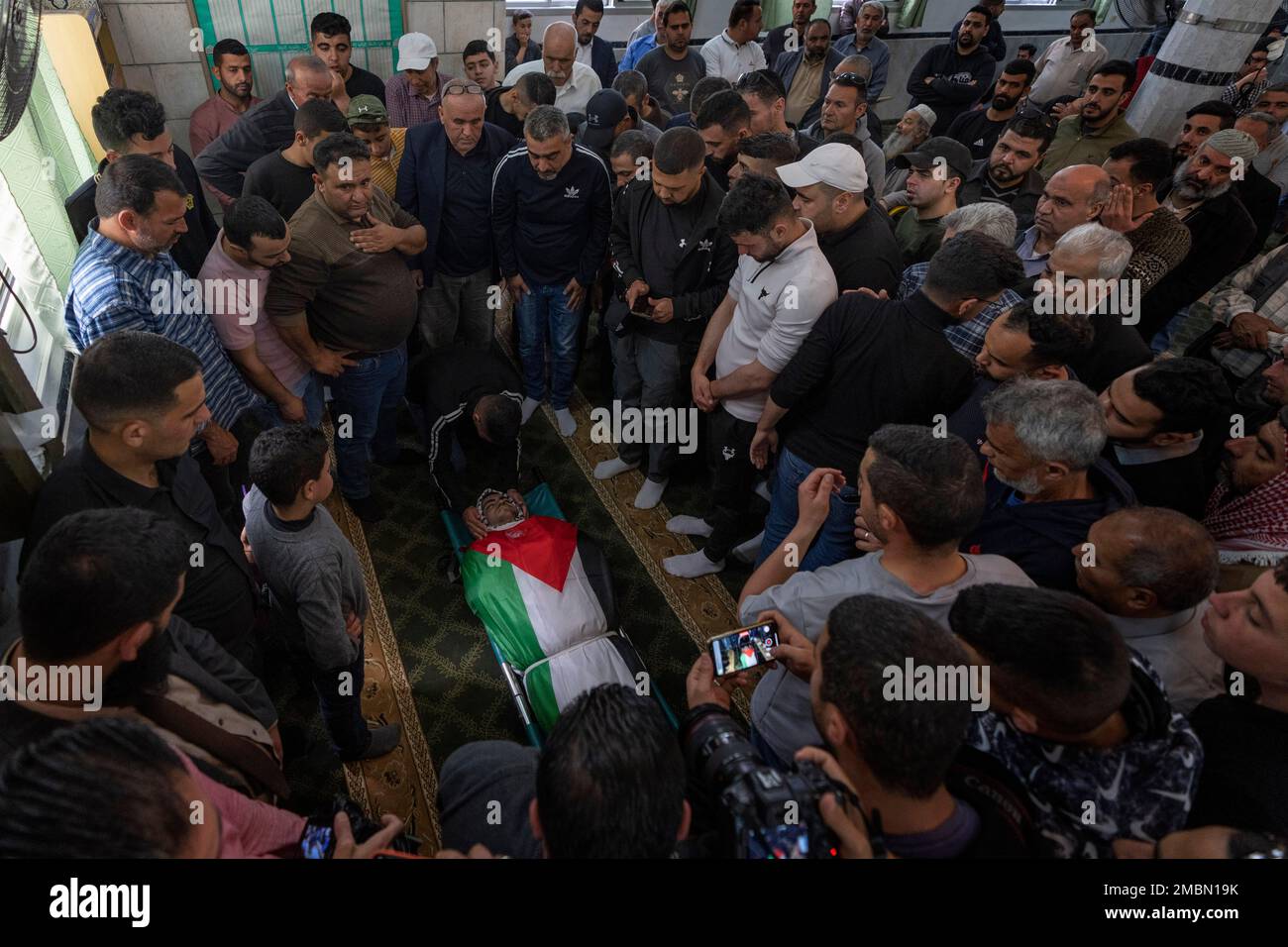 Palestinian mourners take a last look at the body of Muhammad Assaf during his funeral in the ...