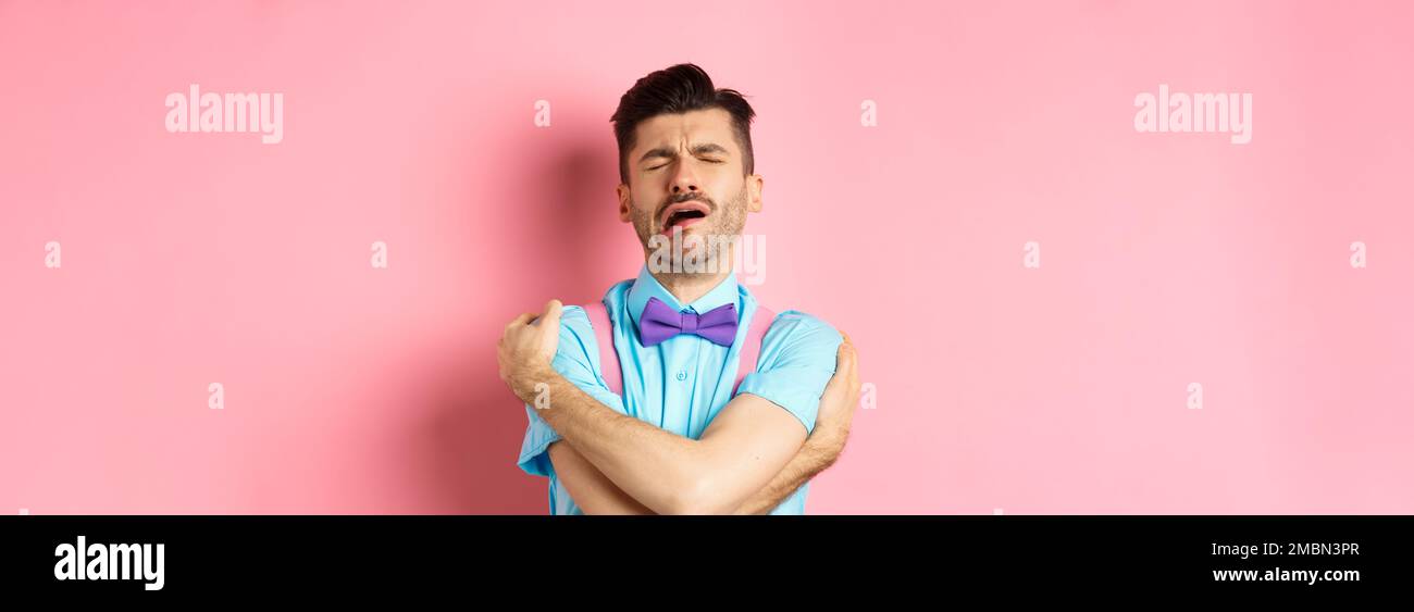 Crying guy hugging himself, feeling sad and lonely, standing unhappy on ...