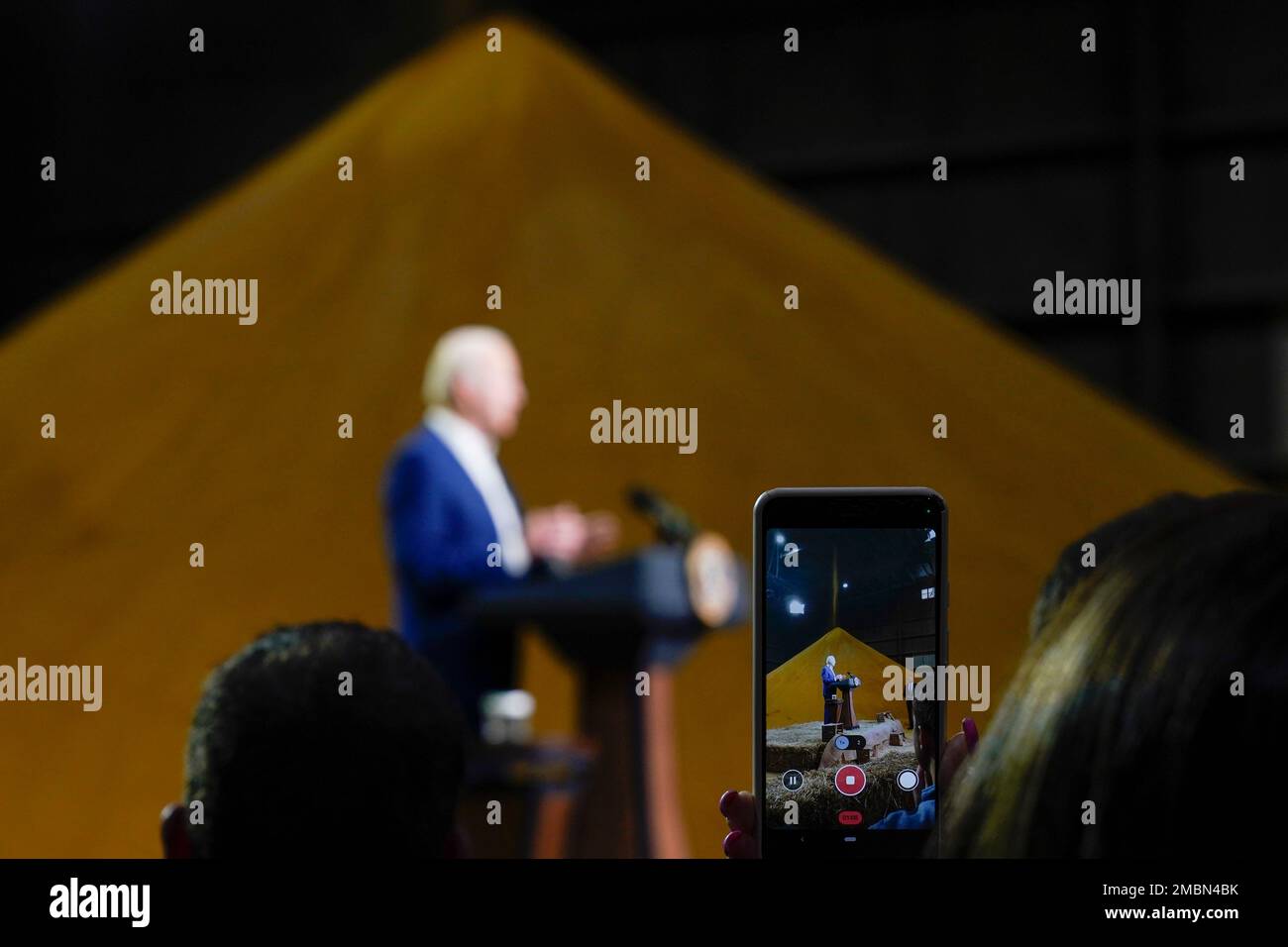 An attendee records a video as President Joe Biden speaks at POET ...