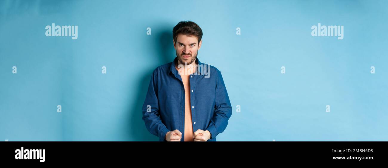 Angry and pissed-off man clench fists and stare with disdain at camera ...