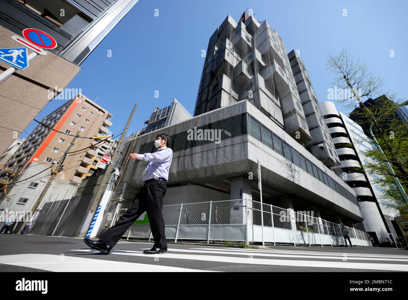A man walks in front of the demolition site of the Nakagin Capsule ...