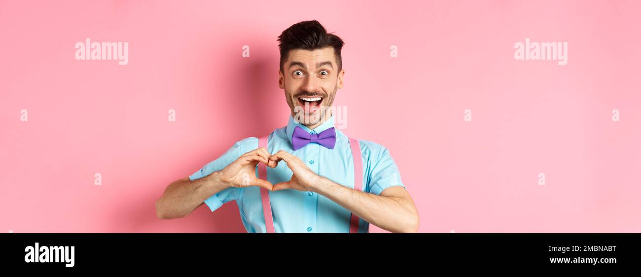 Excited smiling man showing pounding heart and looking with love ...