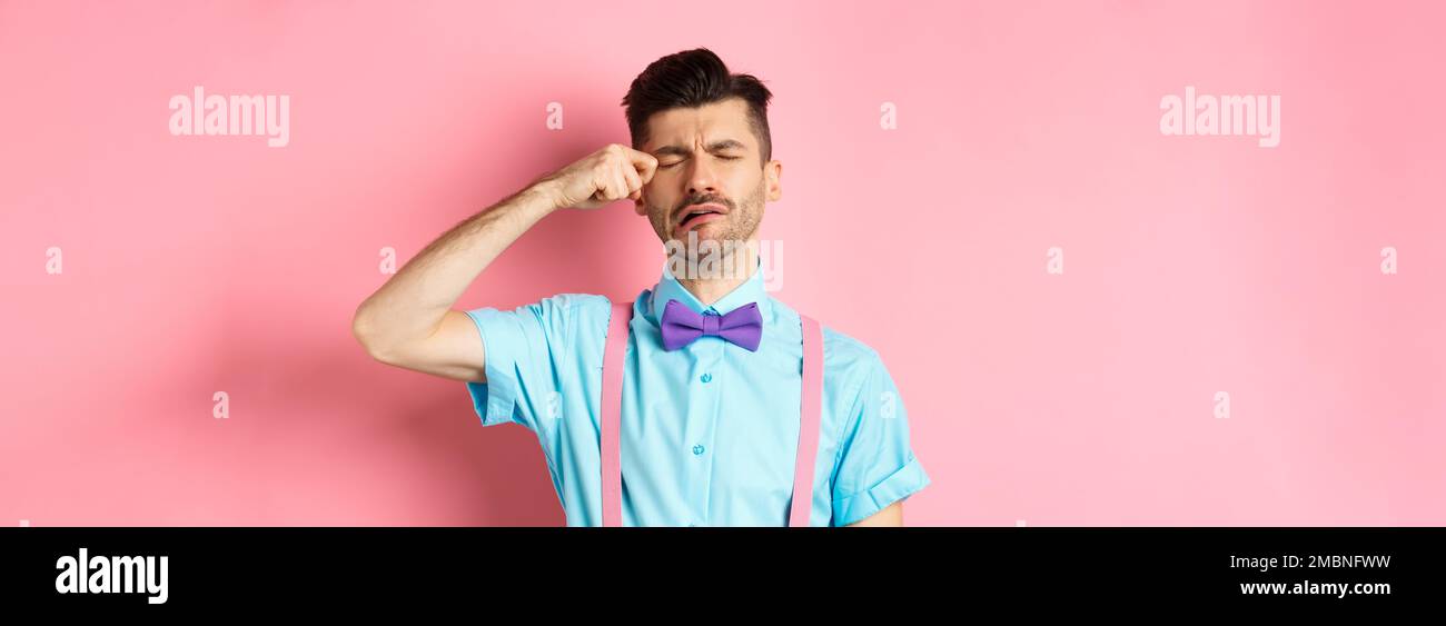 Image of heartbroken guy crying and wiping tear off face, sobbing and ...