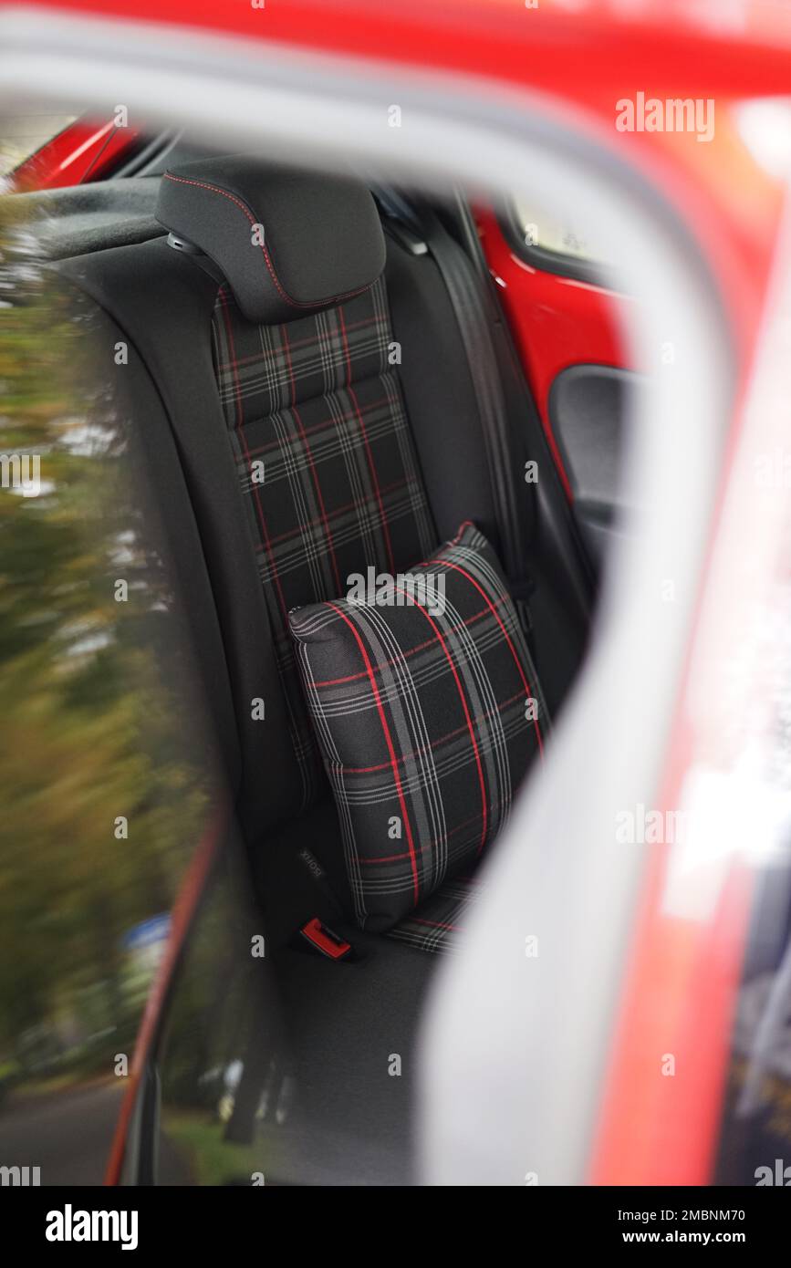 A selective focus shot of a car's interior with black and red checkered ...