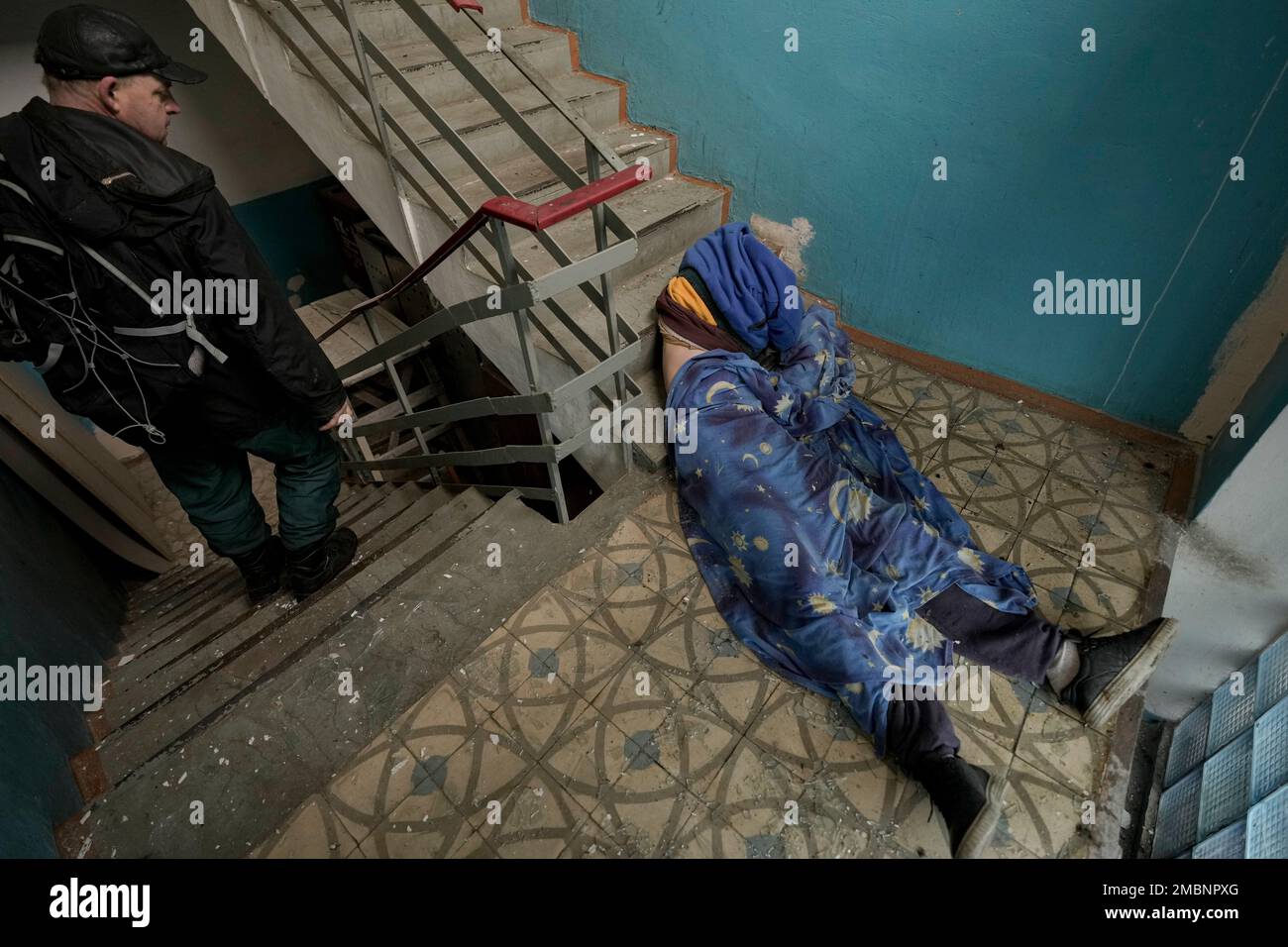 FILE - The body of a man who was killed lies in the staircase of a ...