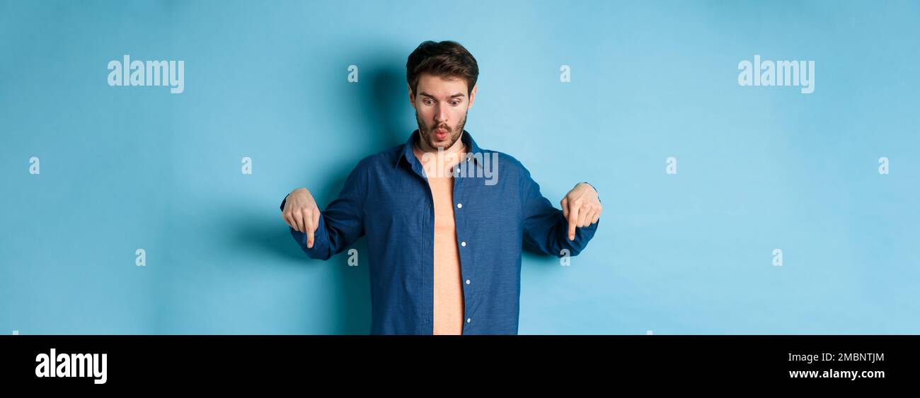 Impressed caucasian male model in casual clothes, say wow, looking and ...