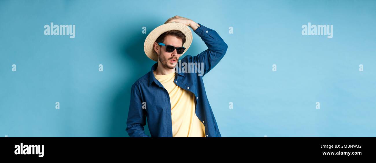 Cool guy having fun on vacation, wearing straw hat and sunglasses ...