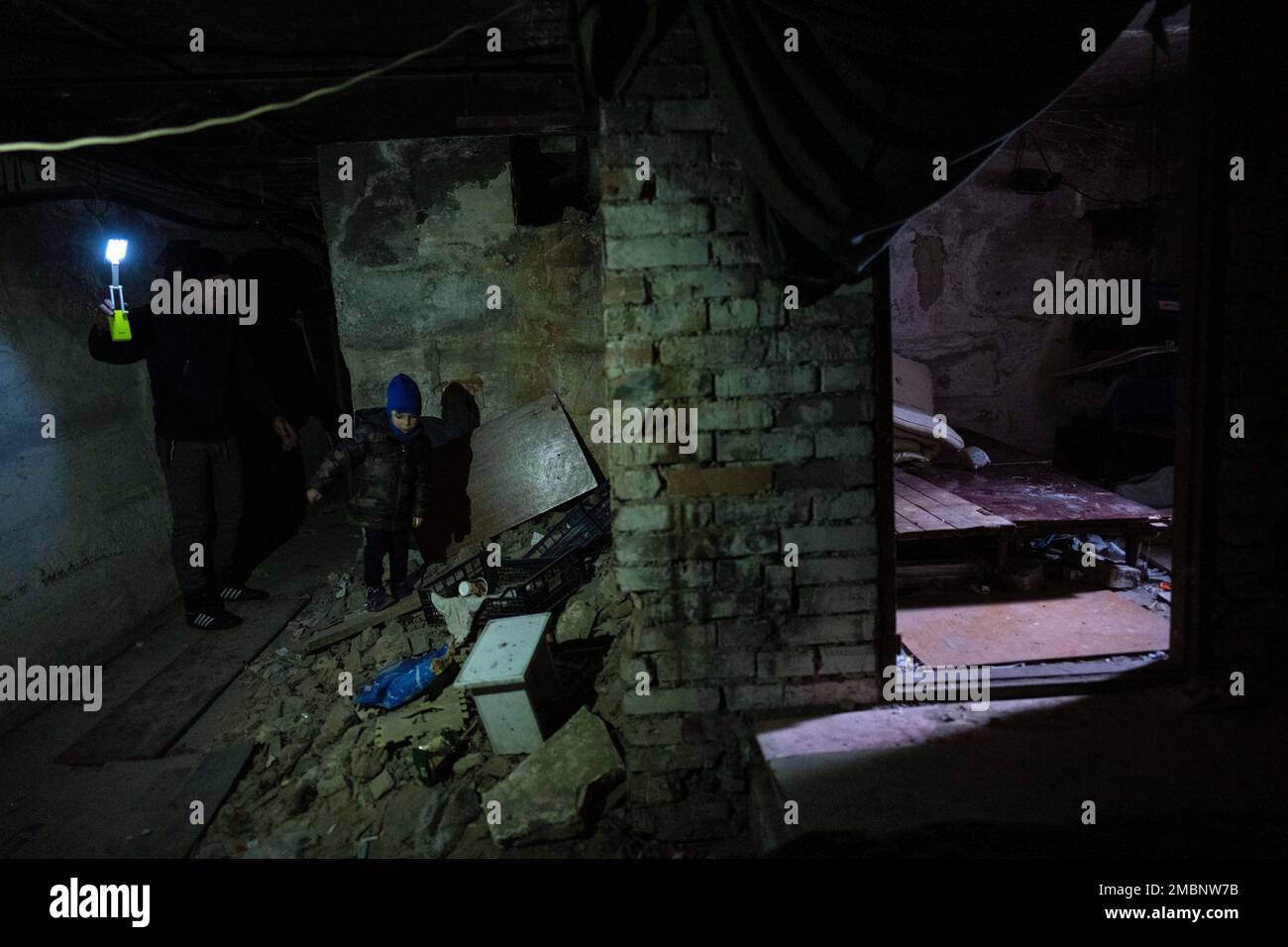 Vlad, 6, walks with his father Ivan, 40, inside the basement where they ...