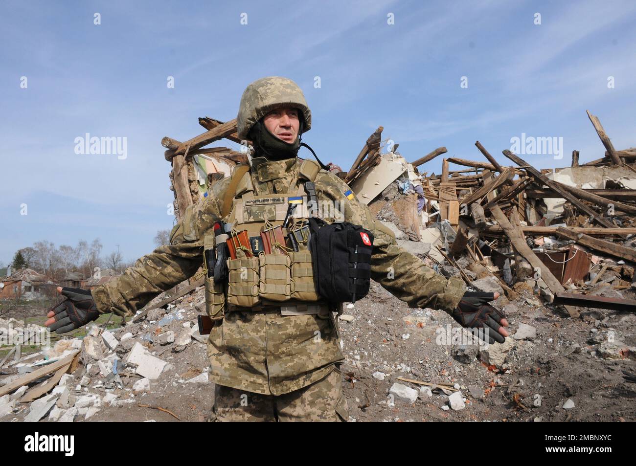 A Ukrainian serviceman opens his arms in front of an apartment building ...