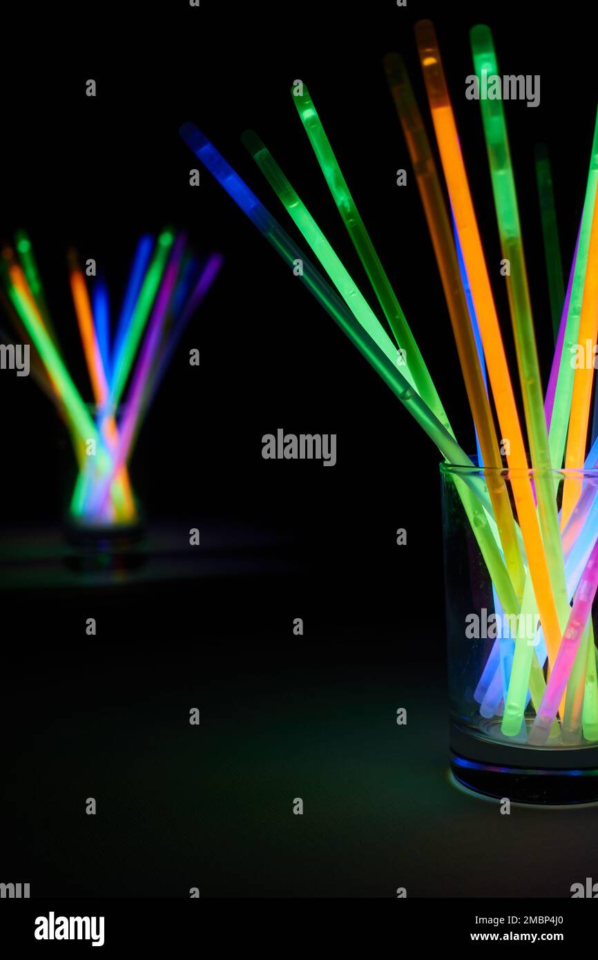 arrangement of multi-colored glow sticks against a black background ...