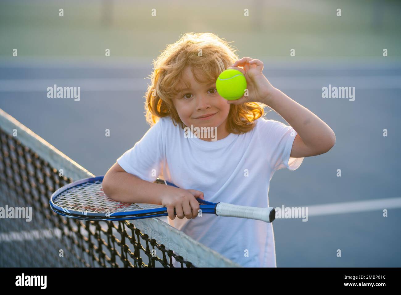 Tennis. Child boy tennis beginner playing tennis on court Stock Photo ...