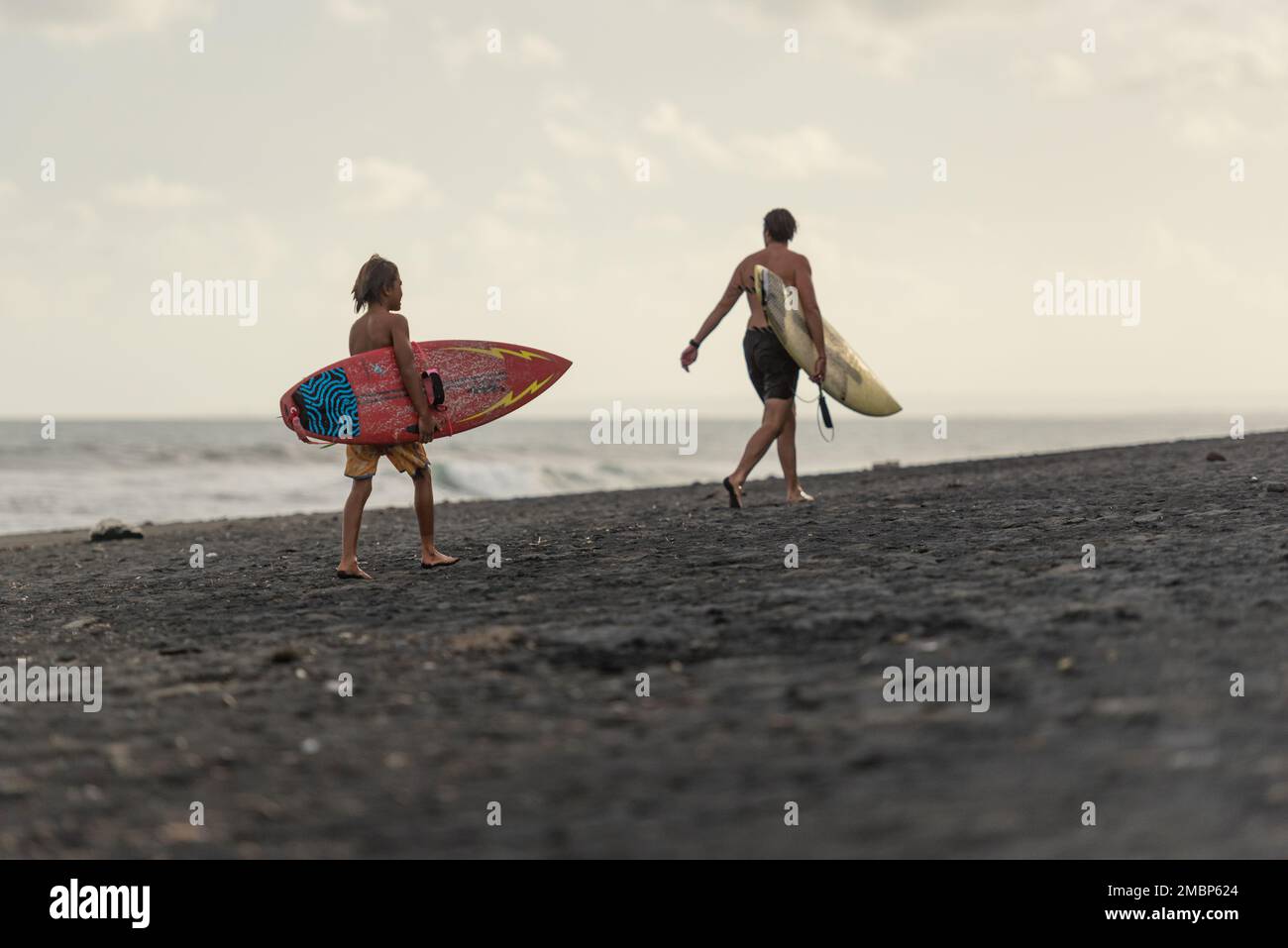 Bali, Indonesia, Man and Women holding a n surfboard on the beach ...