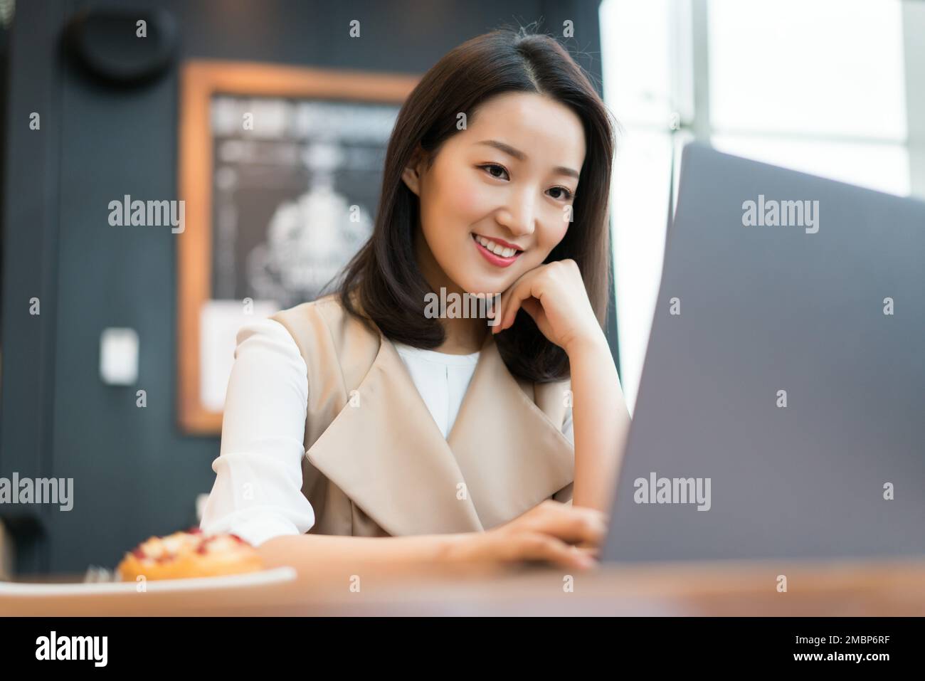 Young woman use the computer in the restaurant Stock Photo - Alamy