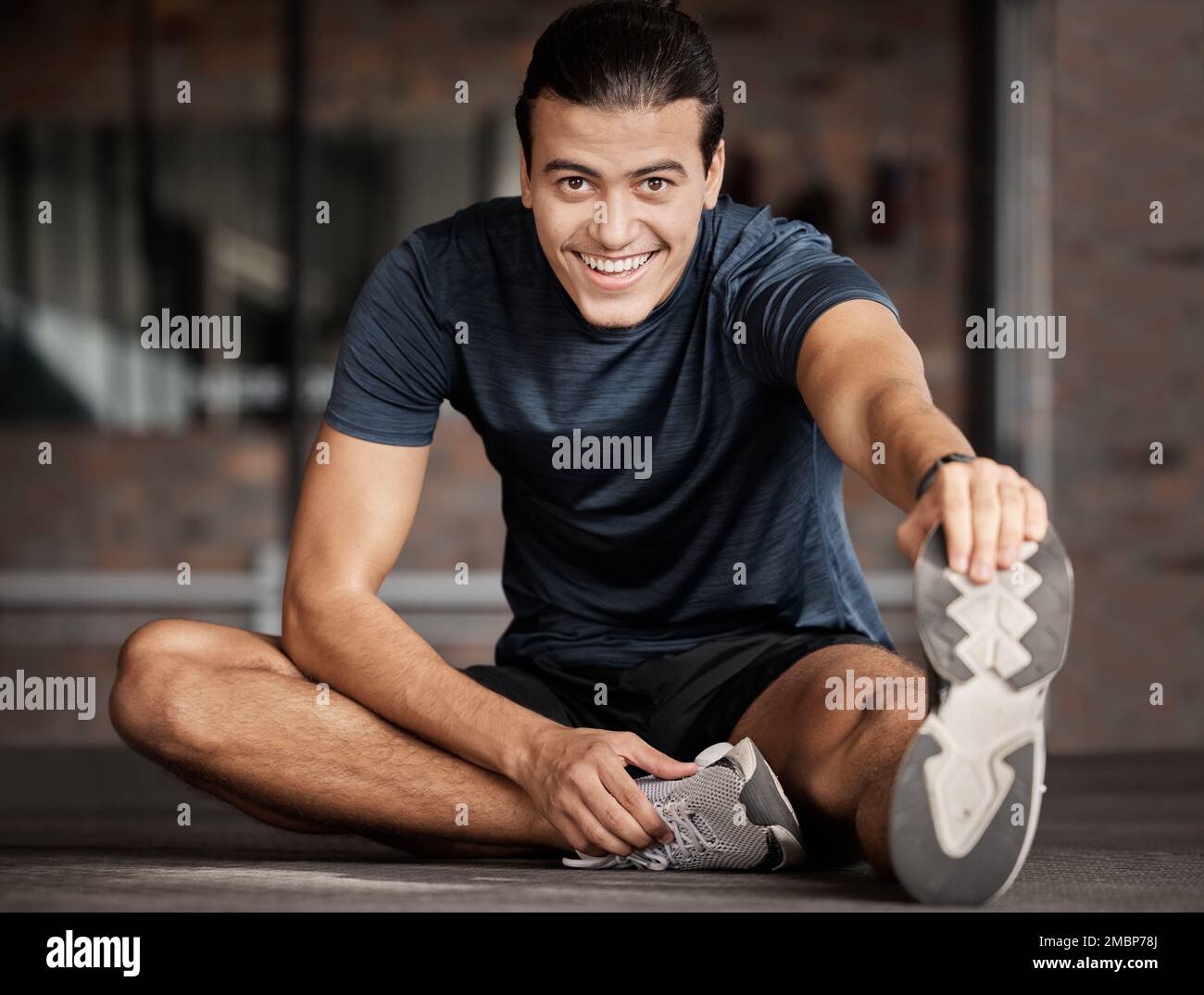 Portrait, fitness and stretching with a man athlete in gym getting ...