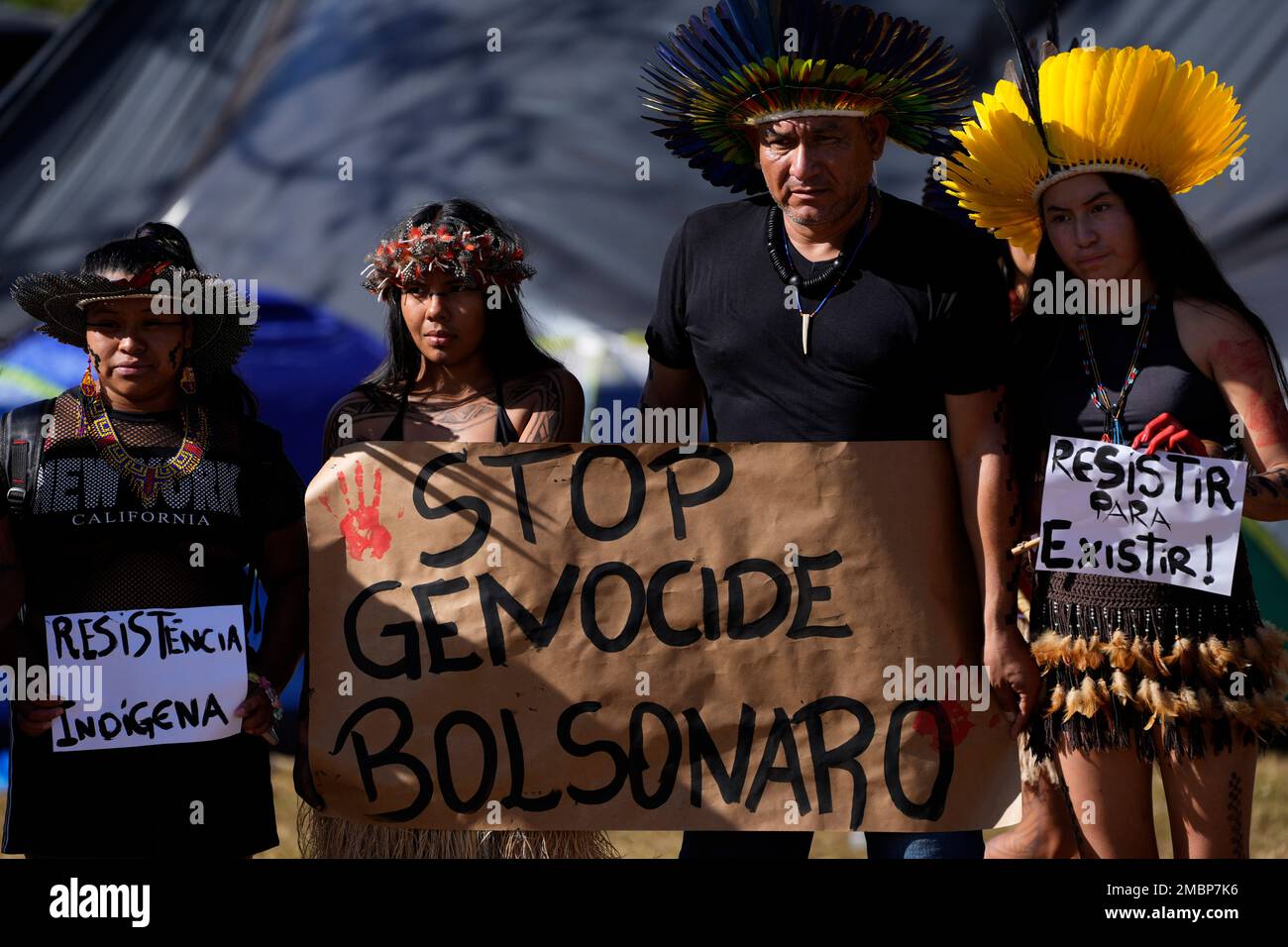A Tembe Indigenous family carries posters written in Portuguese that ...
