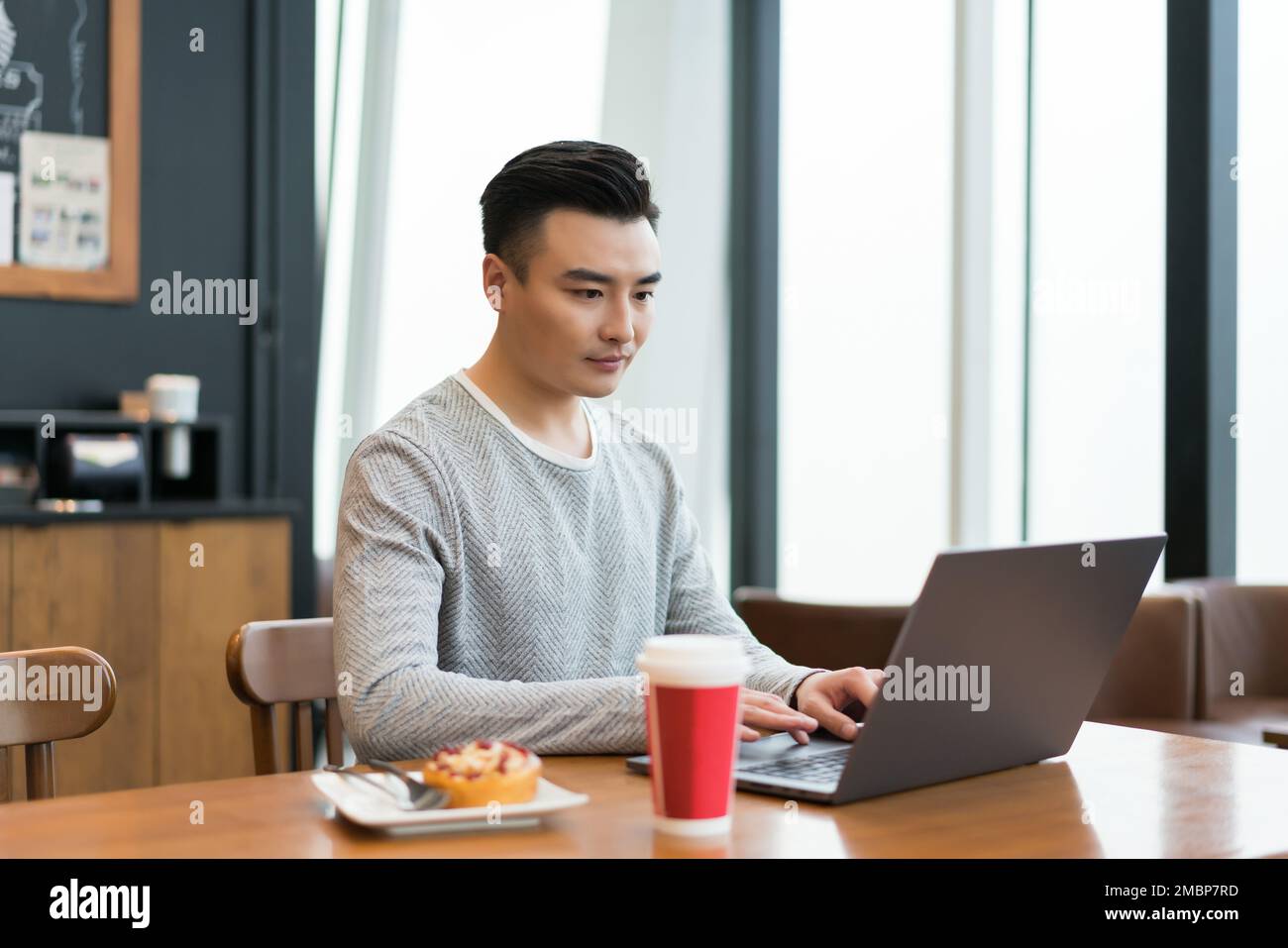 Young men who use a computer in a restaurant Stock Photo - Alamy