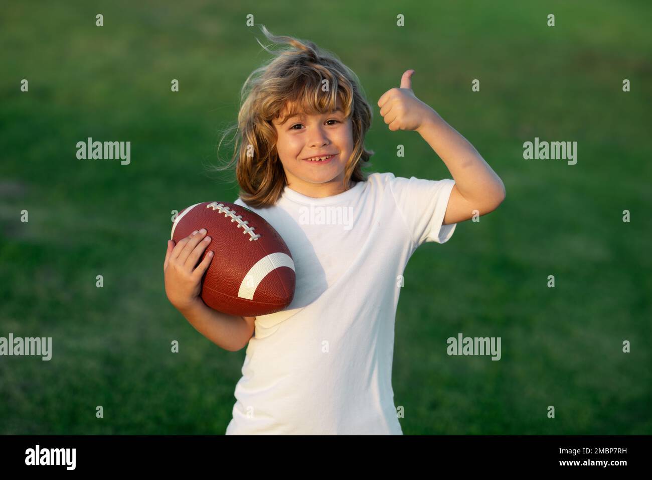Child boy with american football, rugby ball. Kid boy playing with ...