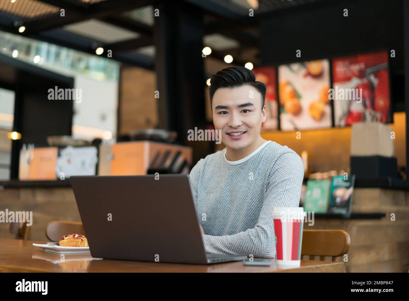 Young men who use a computer in a restaurant Stock Photo - Alamy