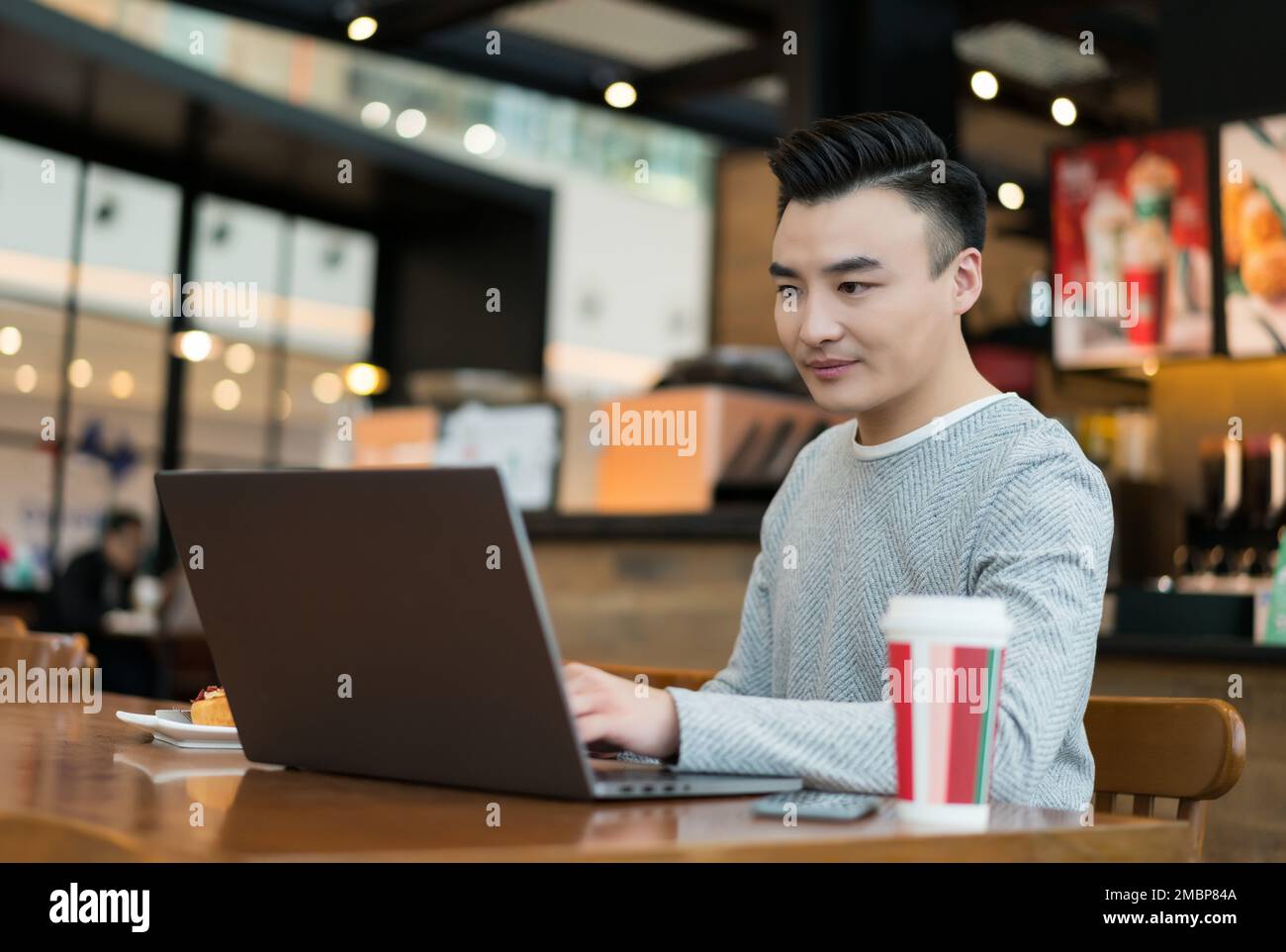 Young men who use a computer in a restaurant Stock Photo - Alamy