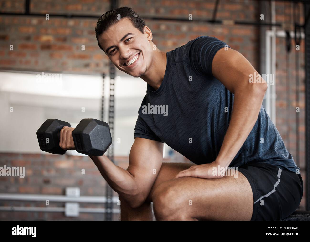 Portrait, fitness and dumbbell with a sports man training in a gym for ...